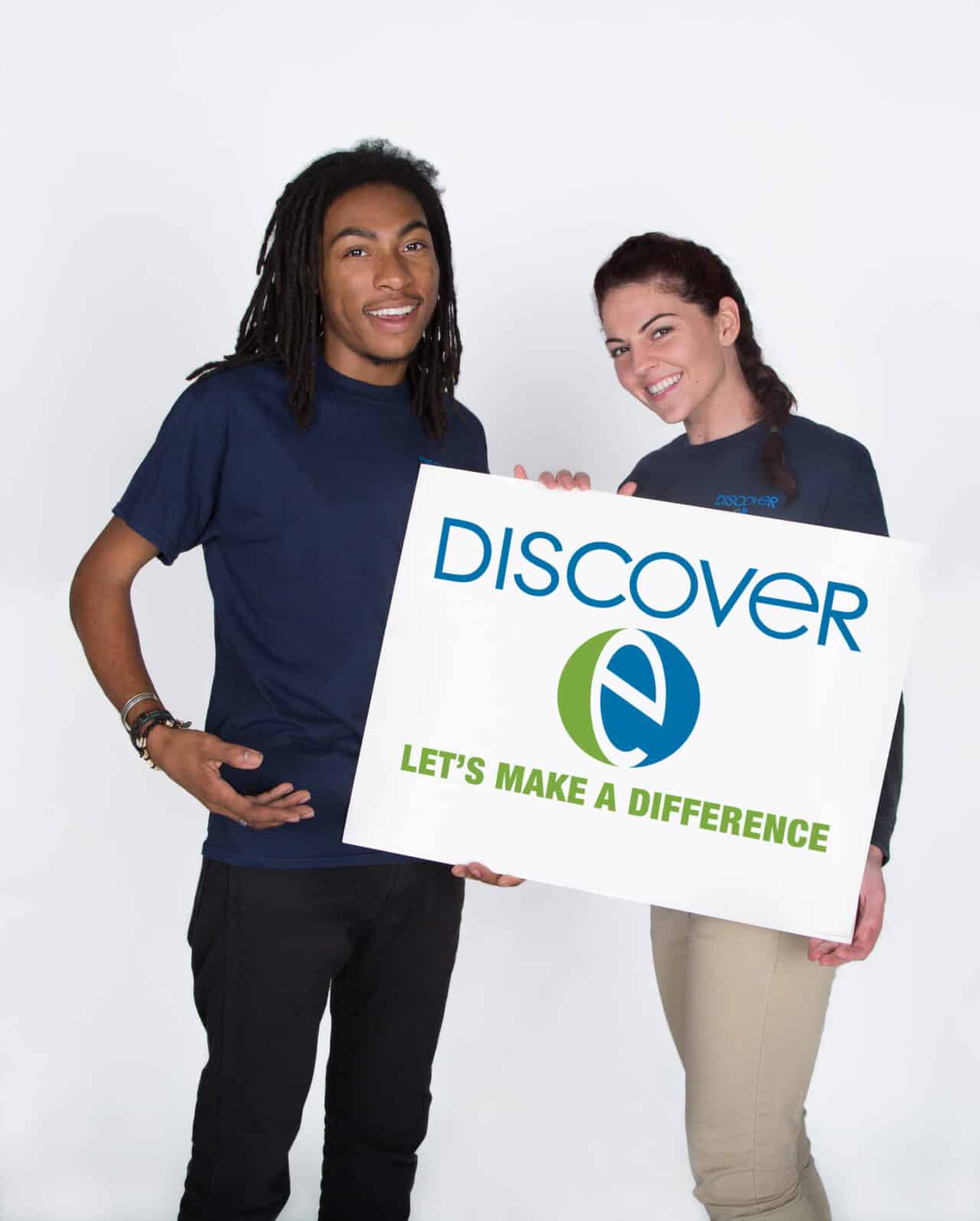 Young Man and Woman Hold DiscoverE Sign - DiscoverE